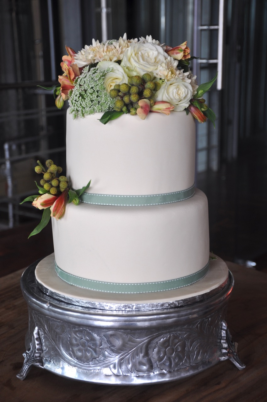 Plain ivory color wedding cake with fresh flowers