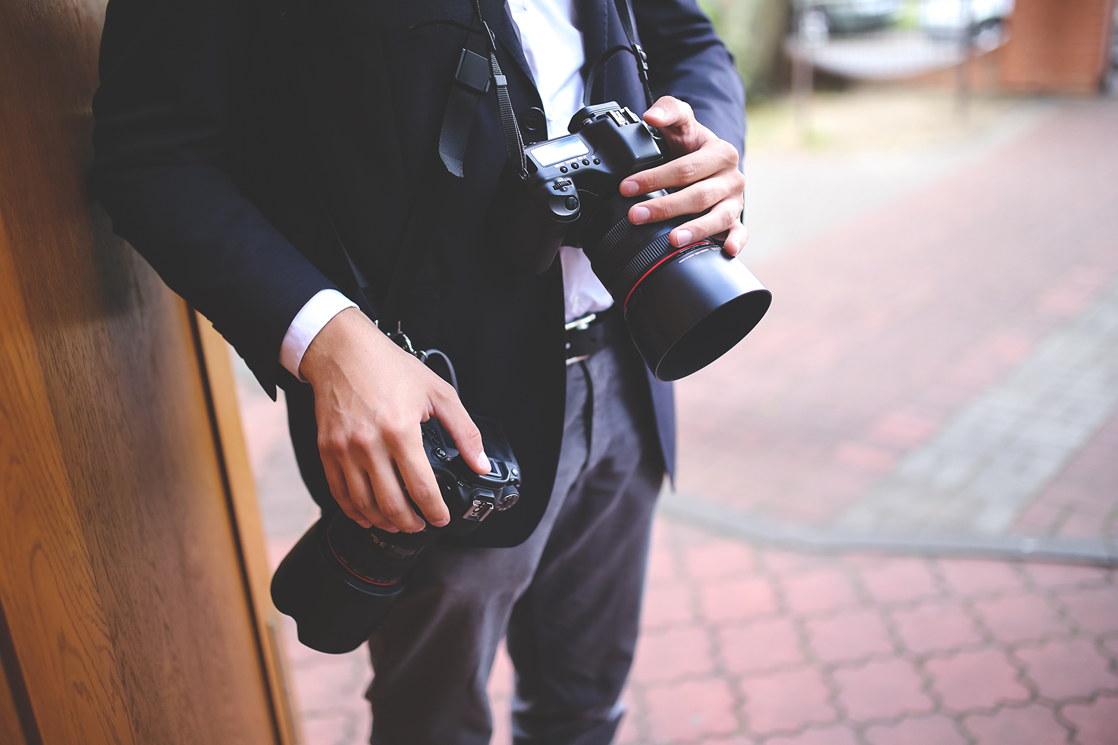 Business man in a suit holding a professional camera - Astonish