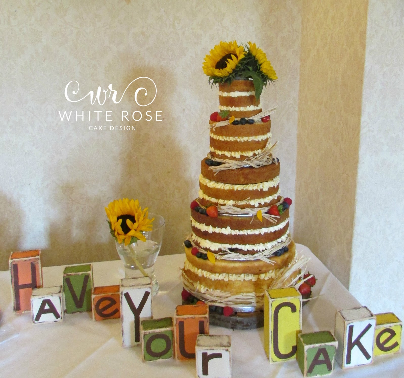 White Rose Cake Design: Five Tier Naked Cake with Sunflowers