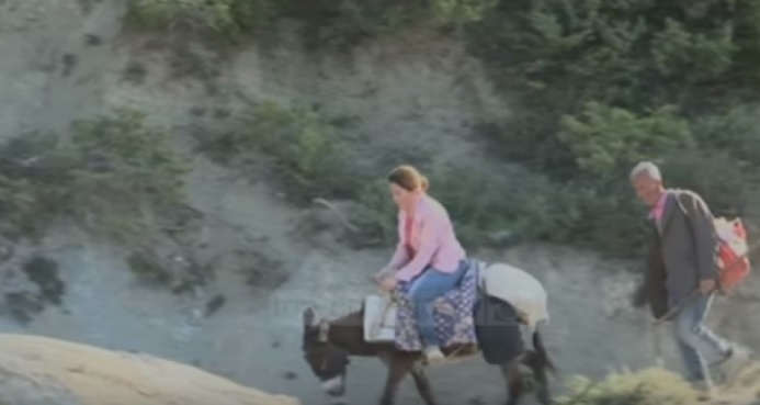 The teacher travels on donkey to school through mountains