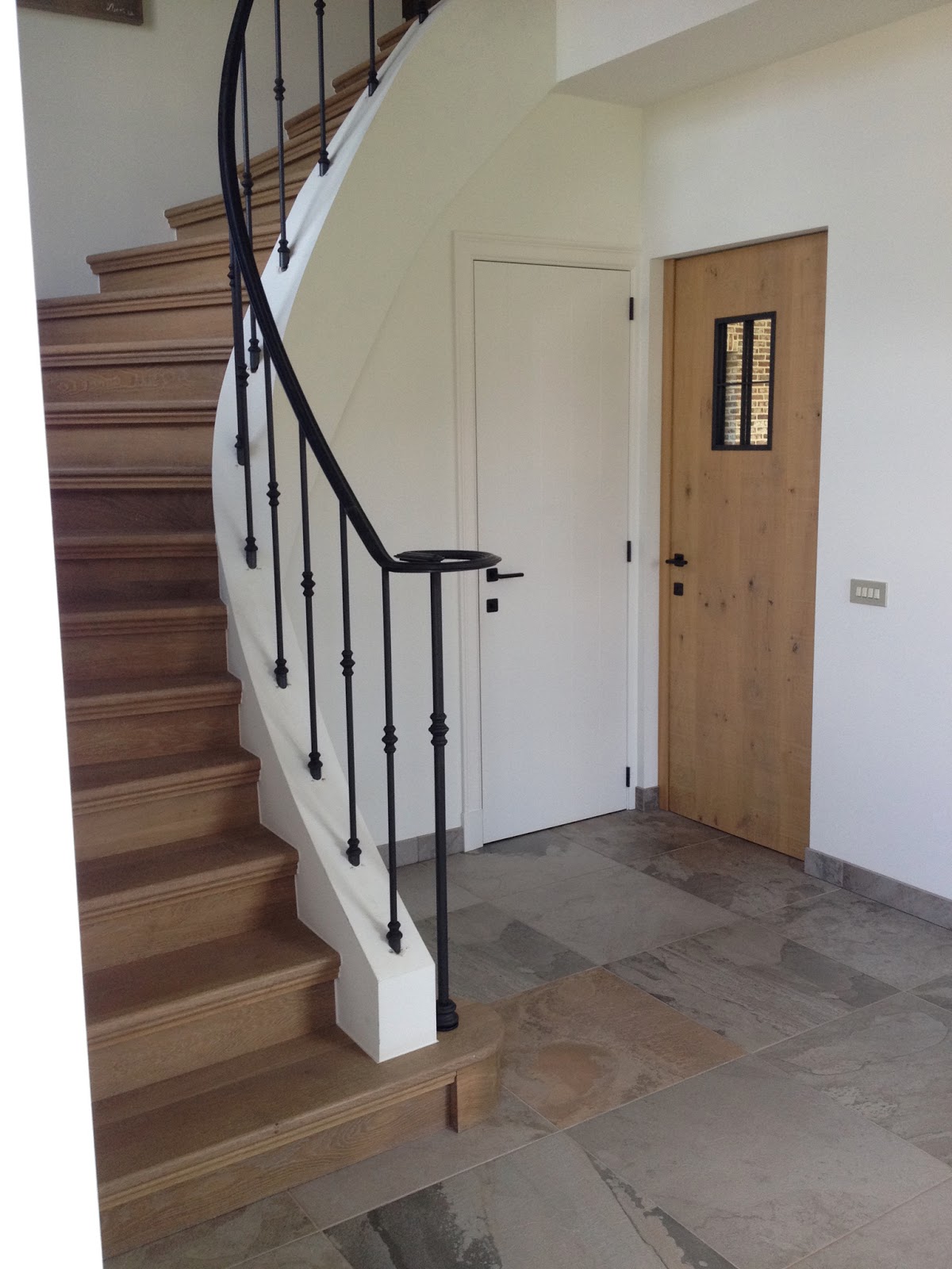 Stalen leuning met ronde spijlen met sierstukken onder geprofileerde ...