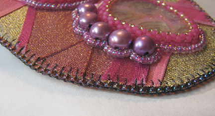 Bead embroidery pendant with a multi-ribbon background