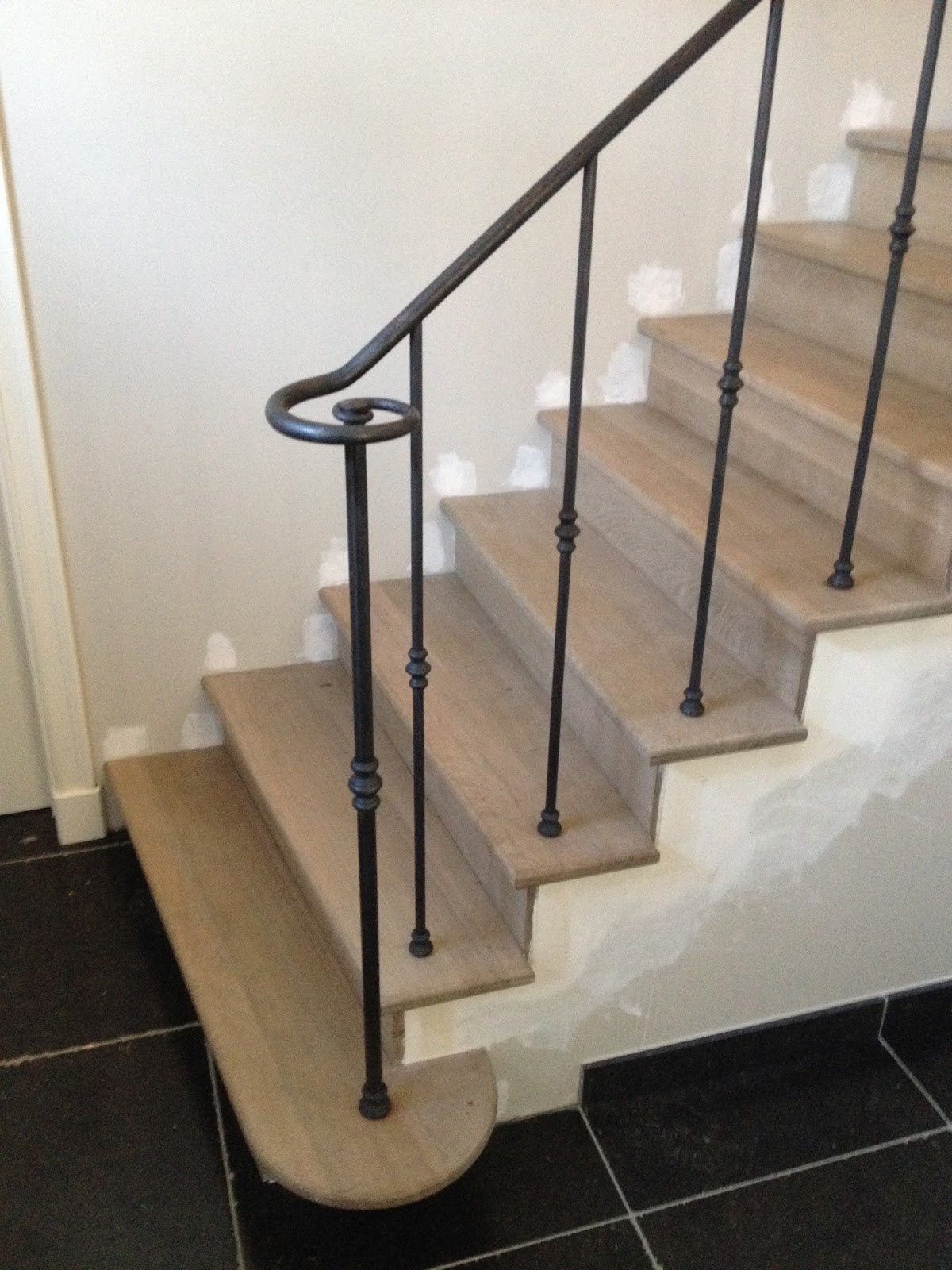 Trapleuning met ronde spijlen en gesmede krul | Van Dinter Metaalvormgeving