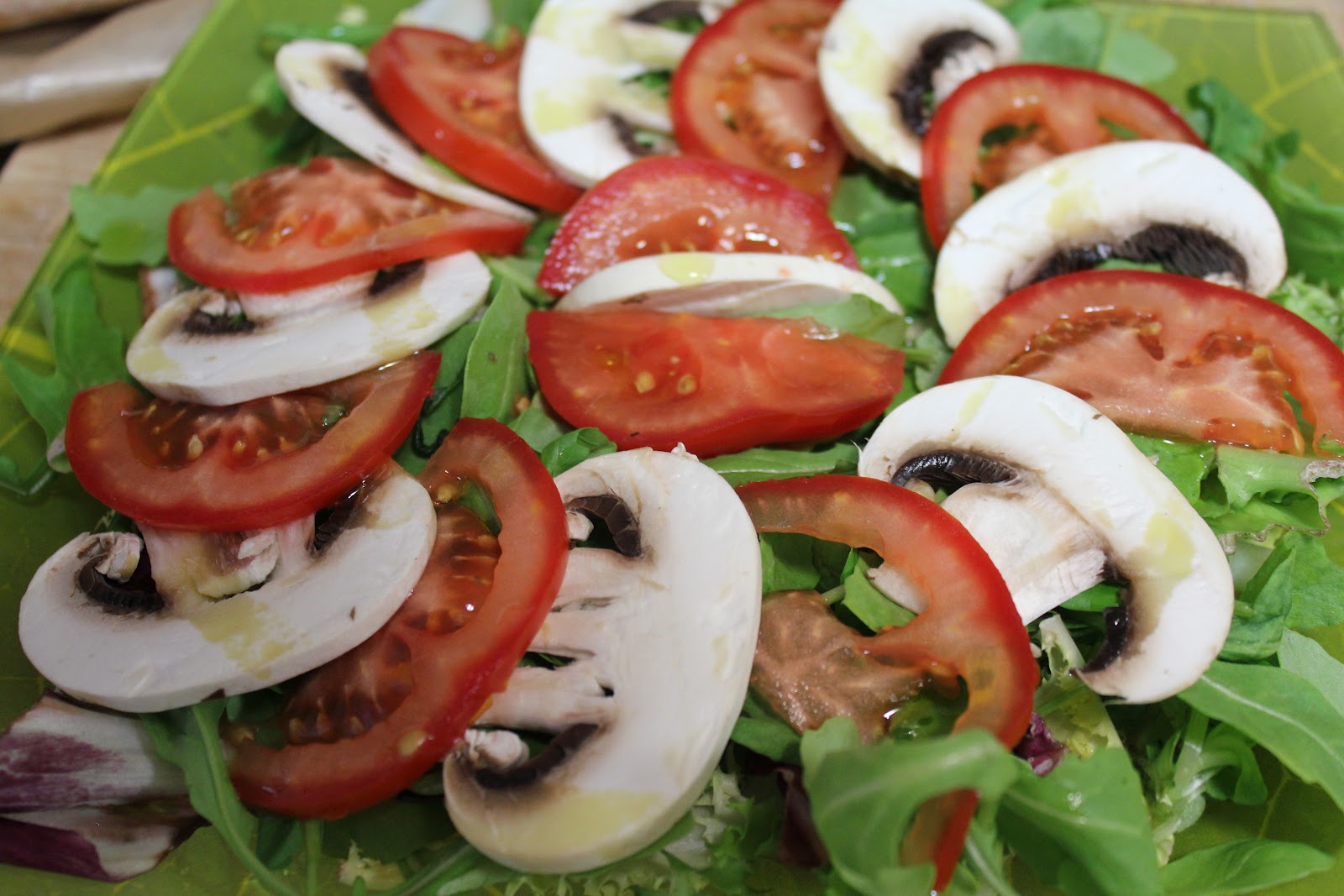 Ensalada de rúcula con tomate, champiñones frescos y parmesano