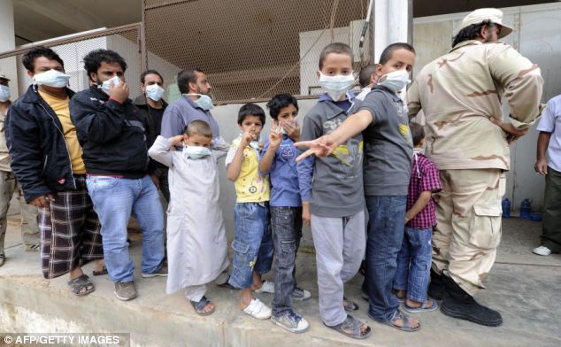 Ghoulish scenes as hundreds queue to gawp at Gaddafi's body as it lies ...