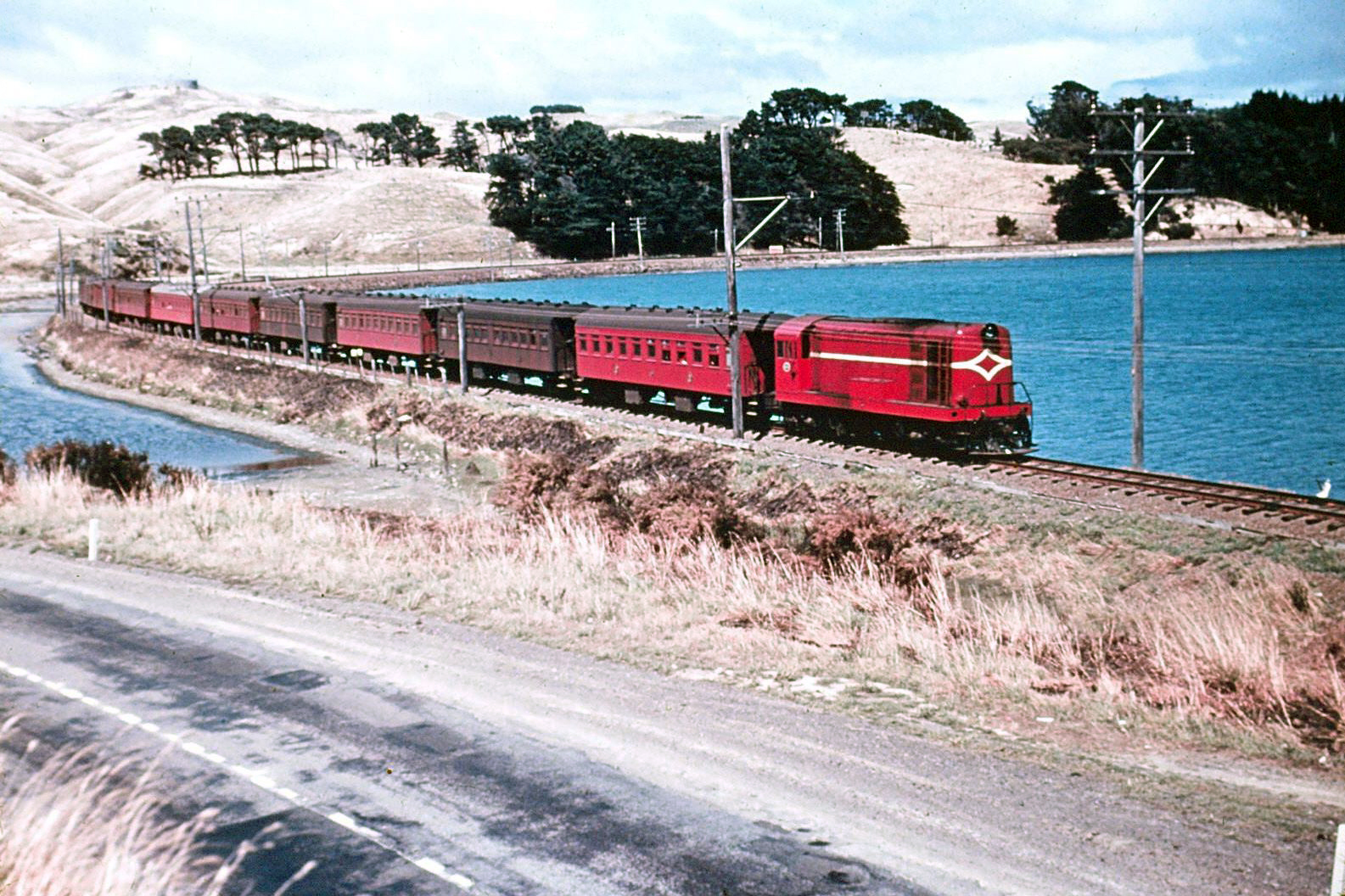 transpress nz: NZR De with a passenger train north of Porirua in 1958