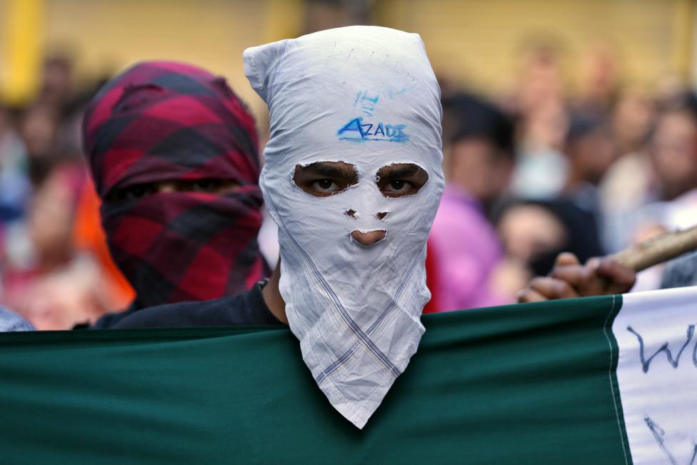 Masked youths attend a demonstration in Srinagar
