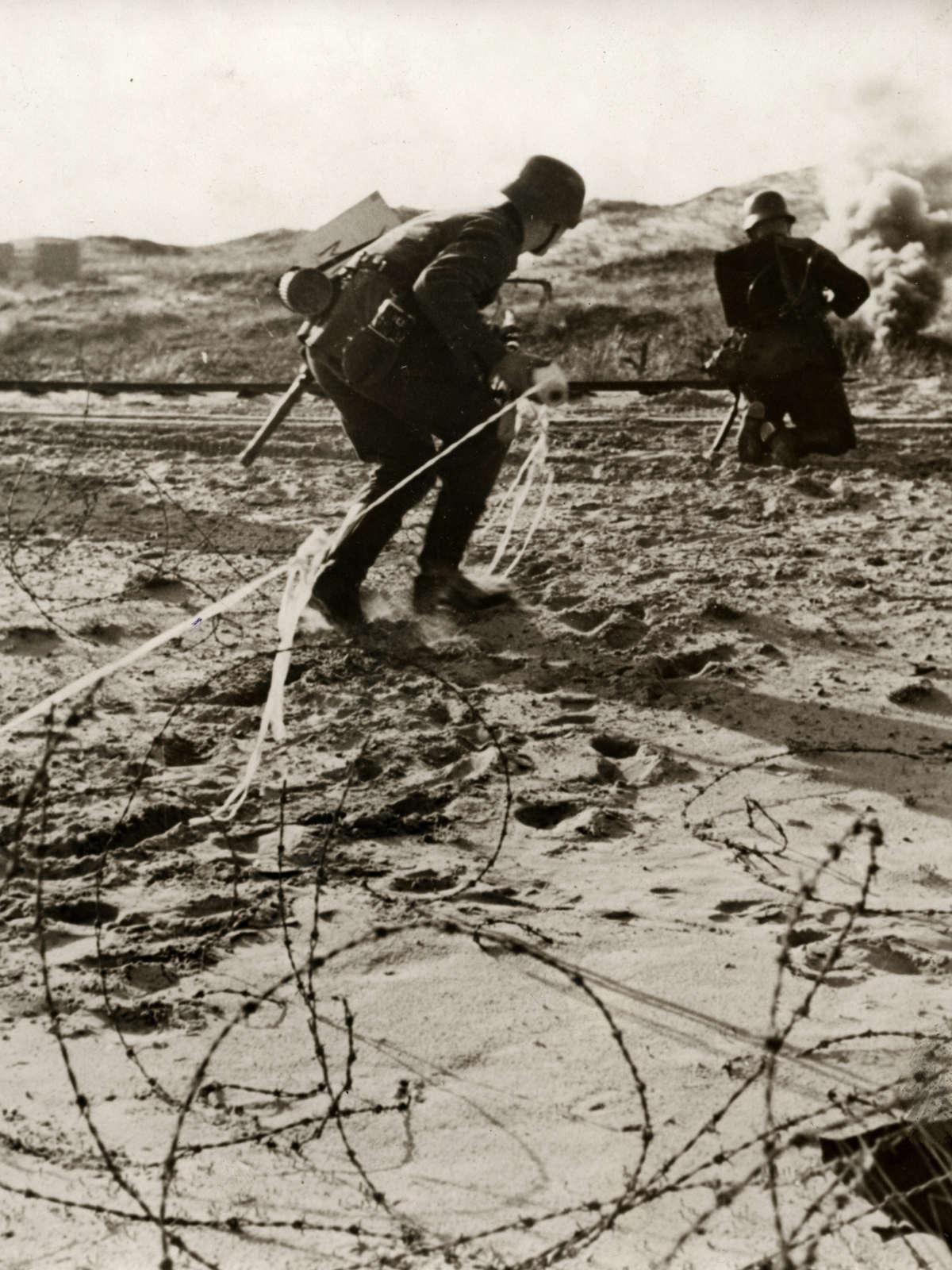 World War II History: Two German soldiers lay warning wires over the ...