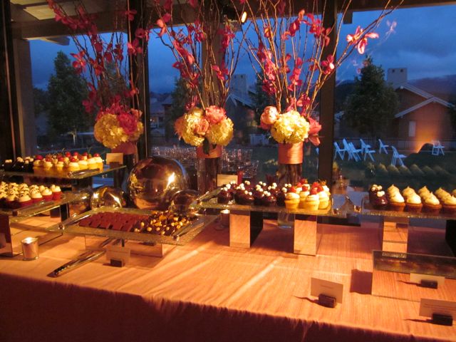 pretty mini dessert buffet setup...With white flowers and gold stems ...