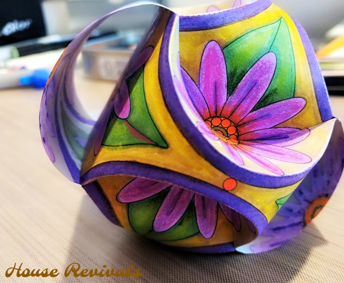 Begin gently folding in the paper, along the curved score lines, taking ...