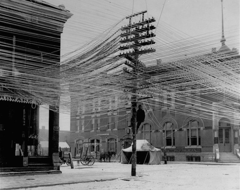 View of a lineman working on power or telephone lines at an ...