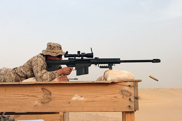 A USMC Scout Sniper fires a M107 Barrett rifle. The M107 features a ...