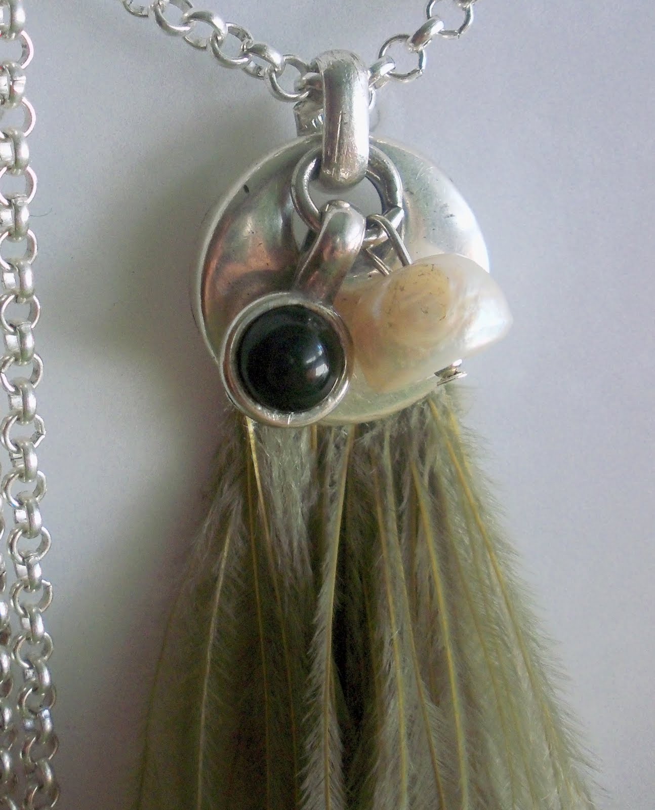 Collar largo con una pluma central. Se puede hacer más corto.