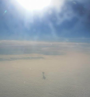 Strange figure spotted walking above clouds by plane passenger