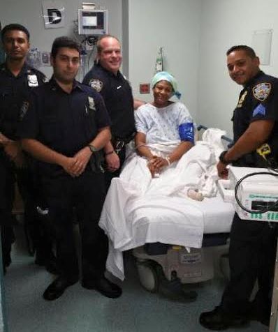 Photo: Four male Police officers help a woman deliver her baby