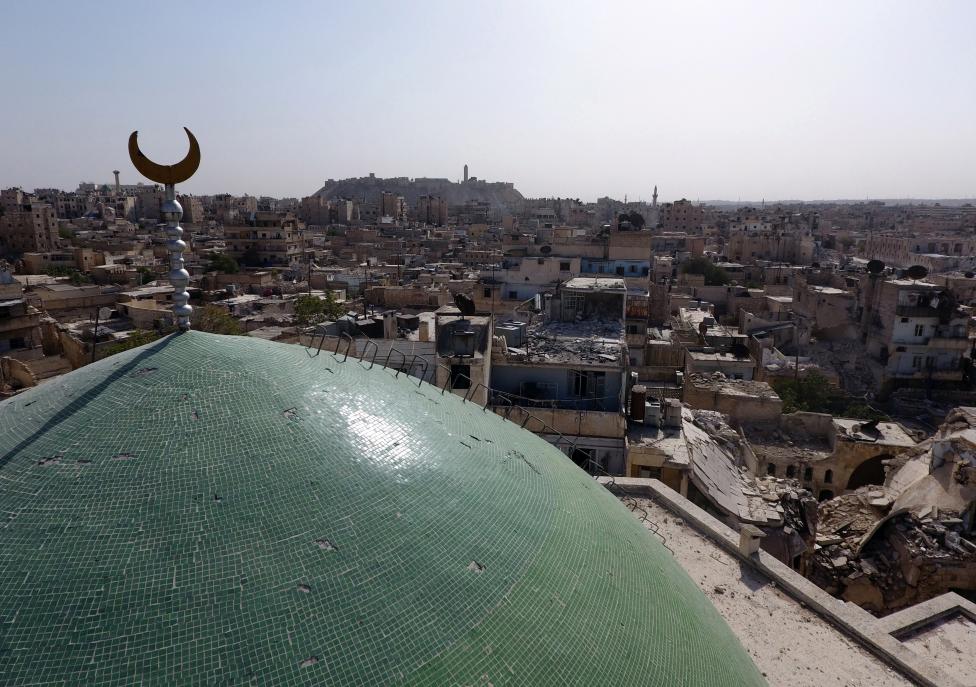 Damaged buildings and a mosque in the old city of Aleppo