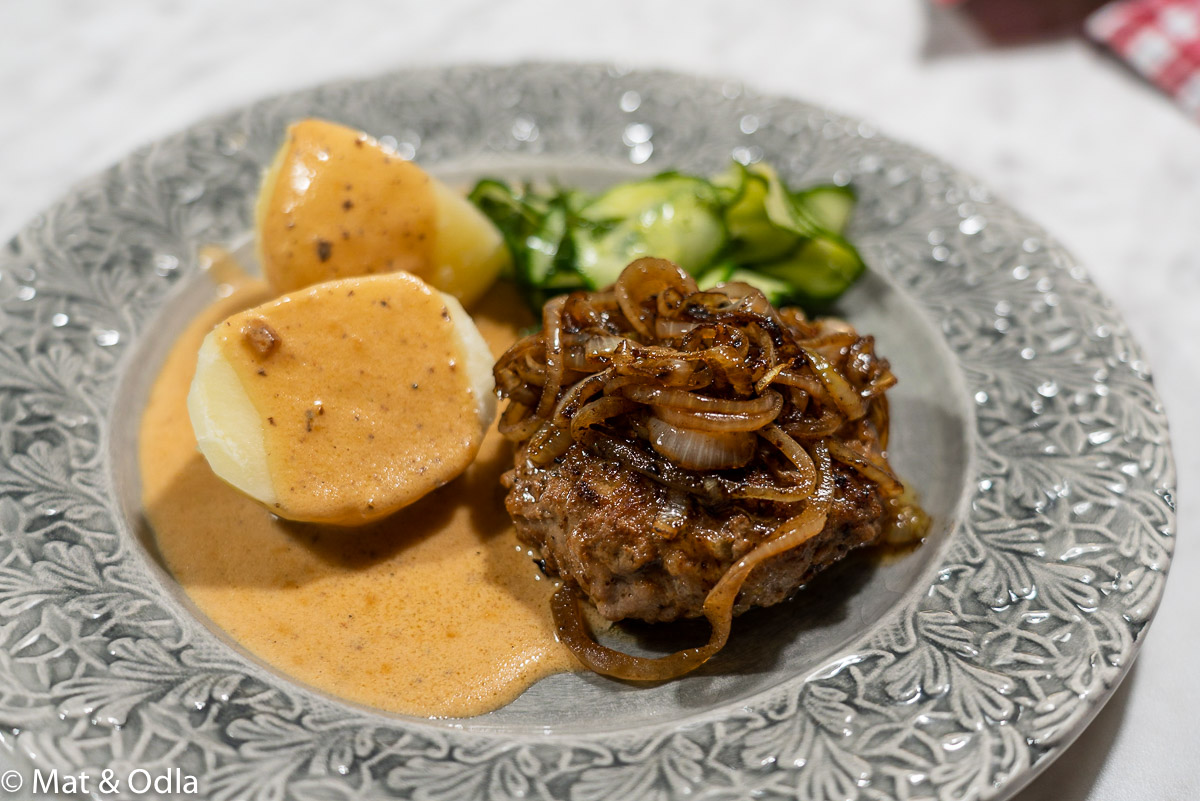Pannbiff med brunsås, stekt lök och inlagd gurka