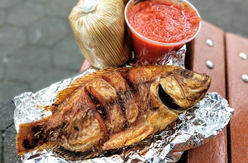 The $8 fish, kenkey, and pepper sauce in the park.