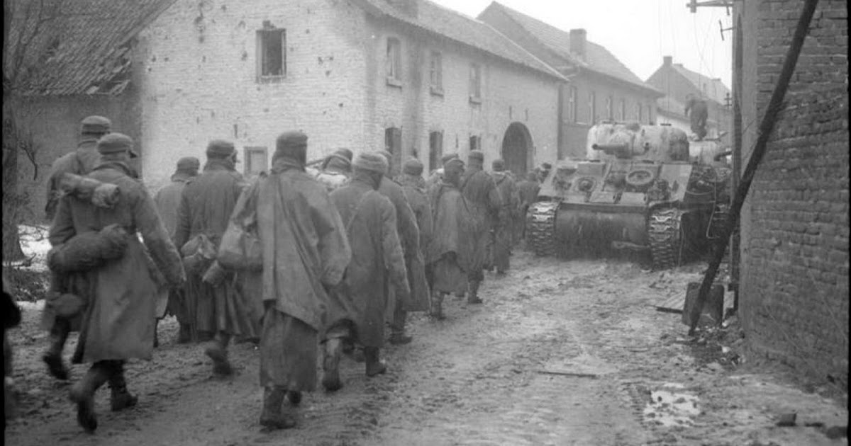 World War II Pictures In Details: German POWs Trudge Past a Sherman Tank