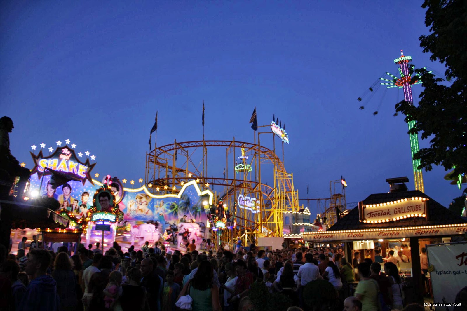 Unterfrankes Welt: Achterbahn auf dem Kiliani Volksfest bei Nacht