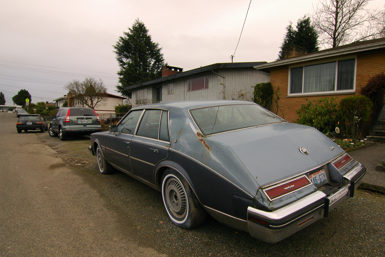 OLD PARKED CARS.: 1983 Cadillac Seville.