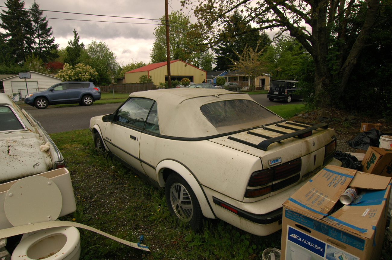 OLD PARKED CARS.: 1988 Pontiac Sunbird GT Turbo Convertible.