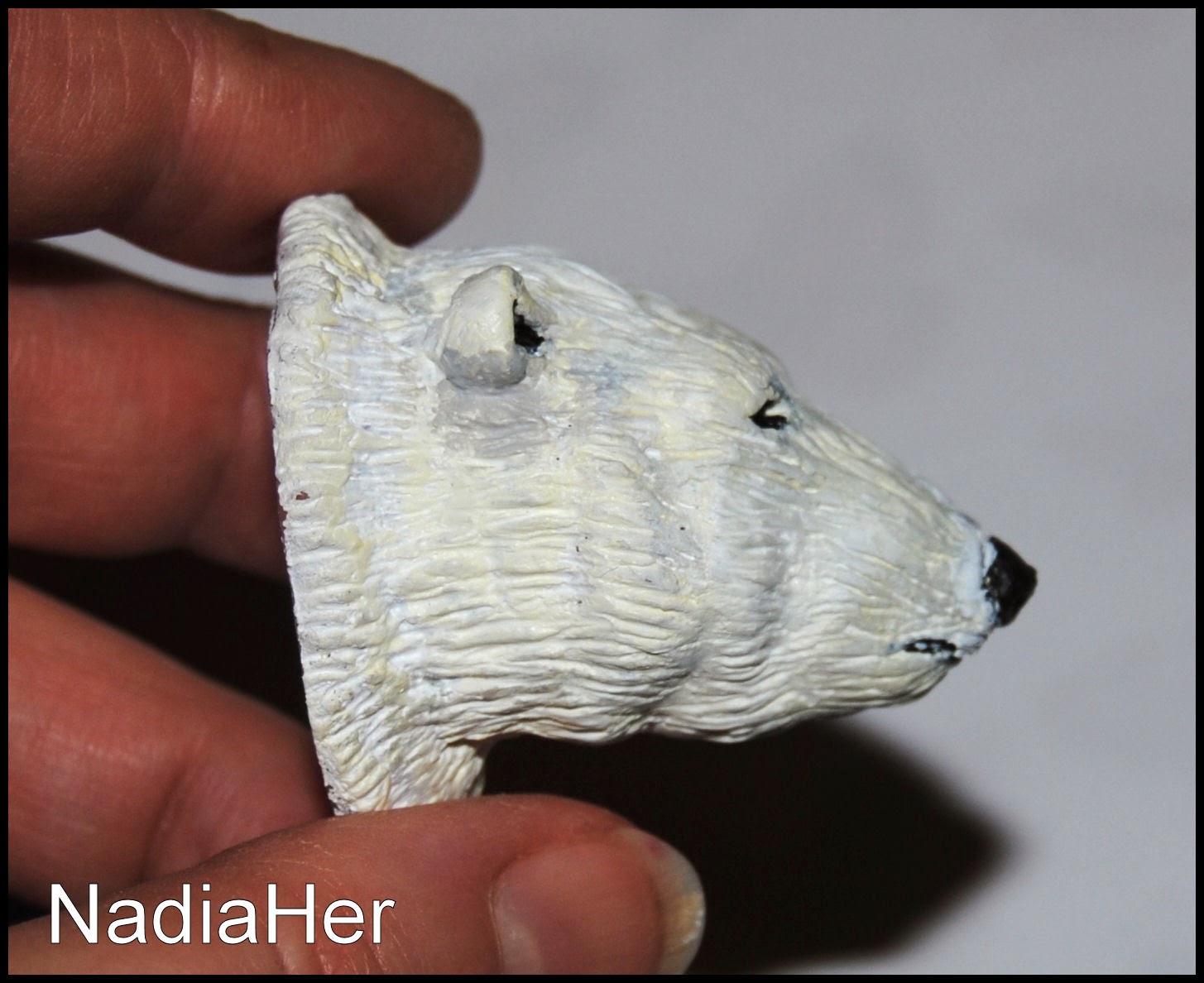 Modelage d'une tête d'un ours polaire en pâte fimo.