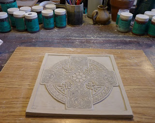 Decorative handmade ceramic tile: New Celtic cross carving in progress