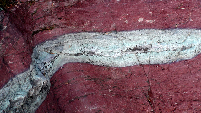 Different layers of red and green-white minerals