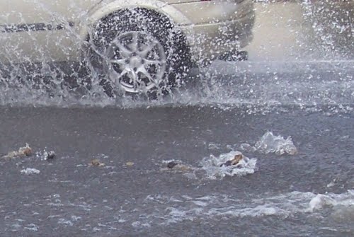 Teresa Schultz: Car wheels spashing in water from a burst water pipe in ...
