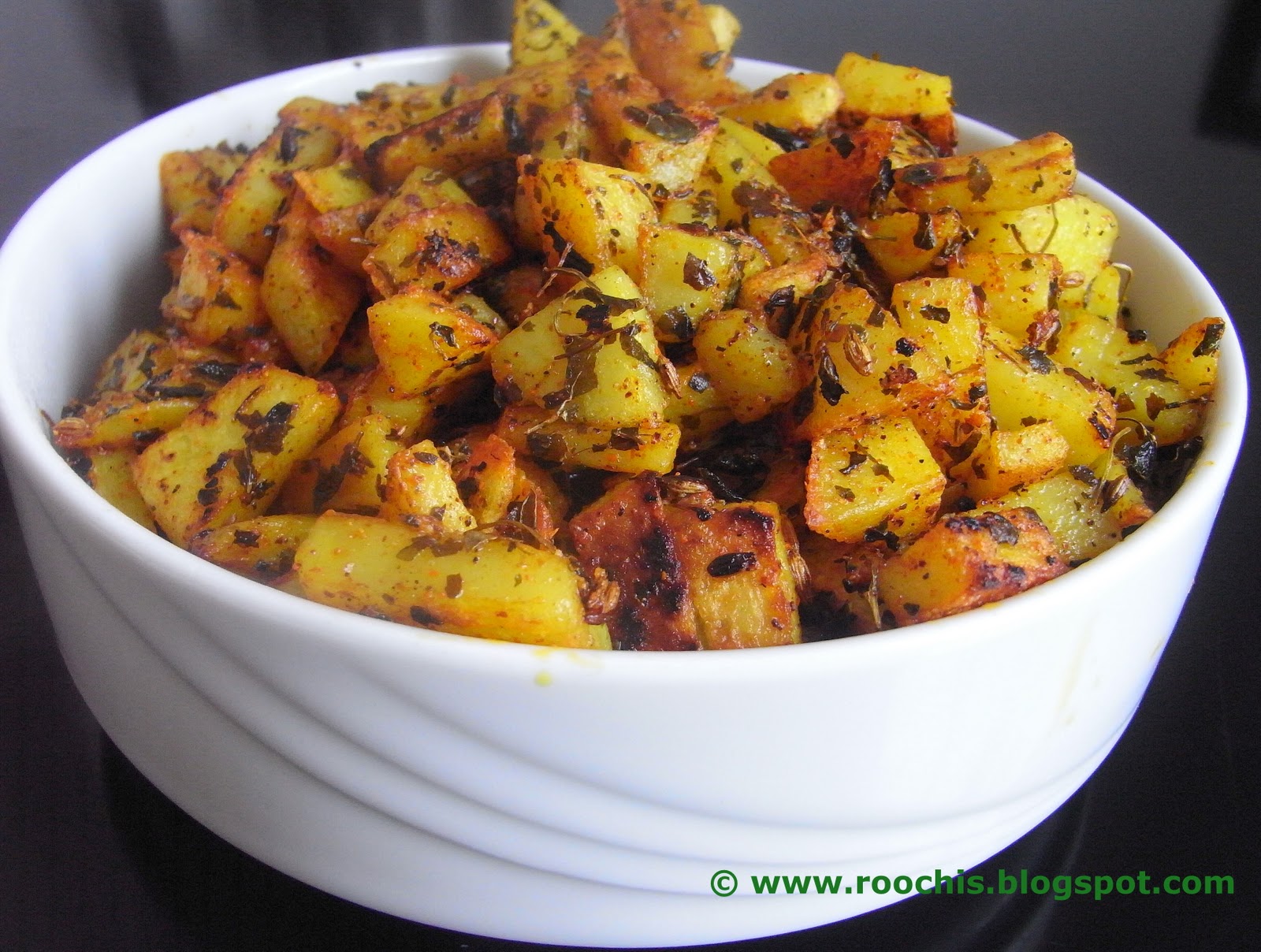 potatoes are chopped into small cubes fried spiced up and garnished ...