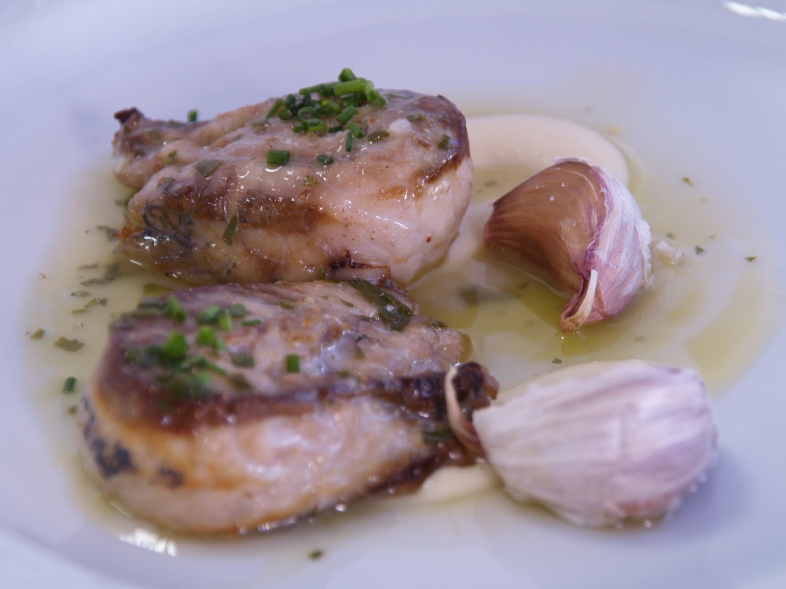 Chicharro al horno con vinagreta deTxacolí y ajo dulce.