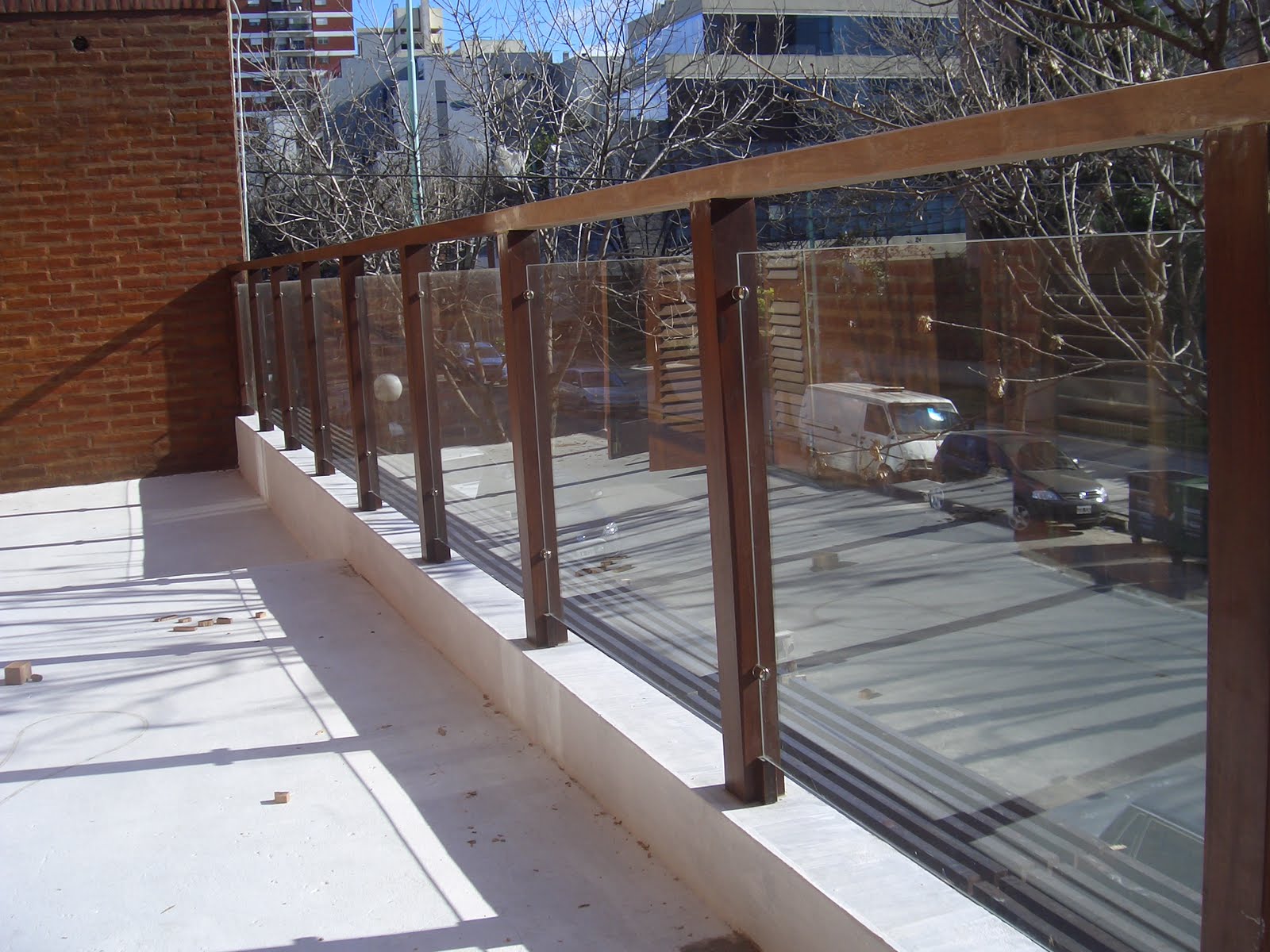 El umbral: Baranda en vidrio laminado y madera de anchico