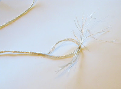 Loop them around the wreath and tuck this part into the ribbon so it’s ...